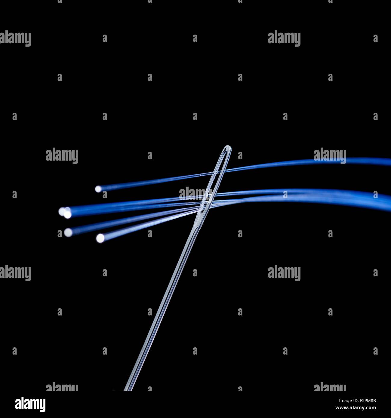 Fibre optics being thread through a needle, close up Stock Photo - Alamy
