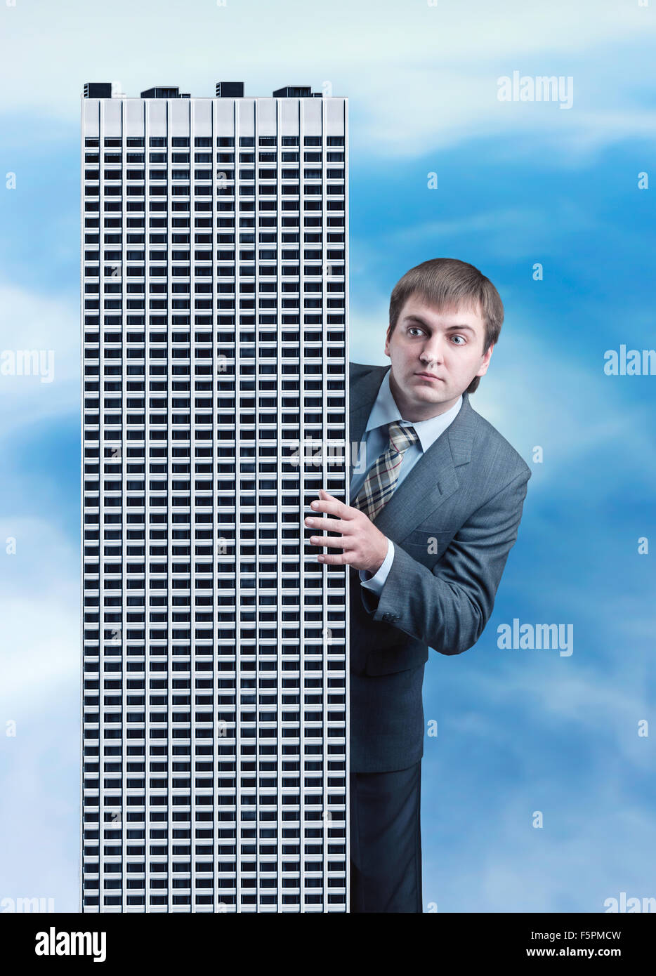 Businessman stands behind the office building against blue sky Stock ...