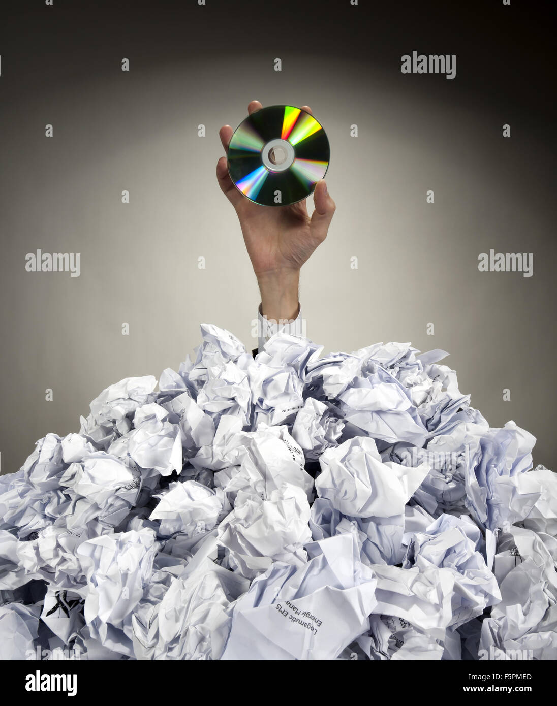 Hand with CD reaches out from big heap of crumpled papers Stock Photo ...