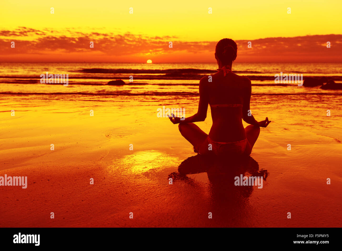 Meditation on the beach at sunset Stock Photo - Alamy