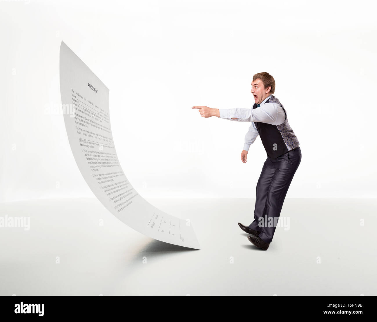 Afraid man on white background points to the document Stock Photo - Alamy