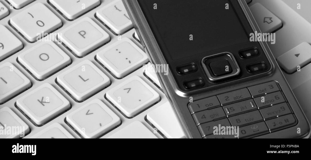Phone on keyboard Stock Photo - Alamy