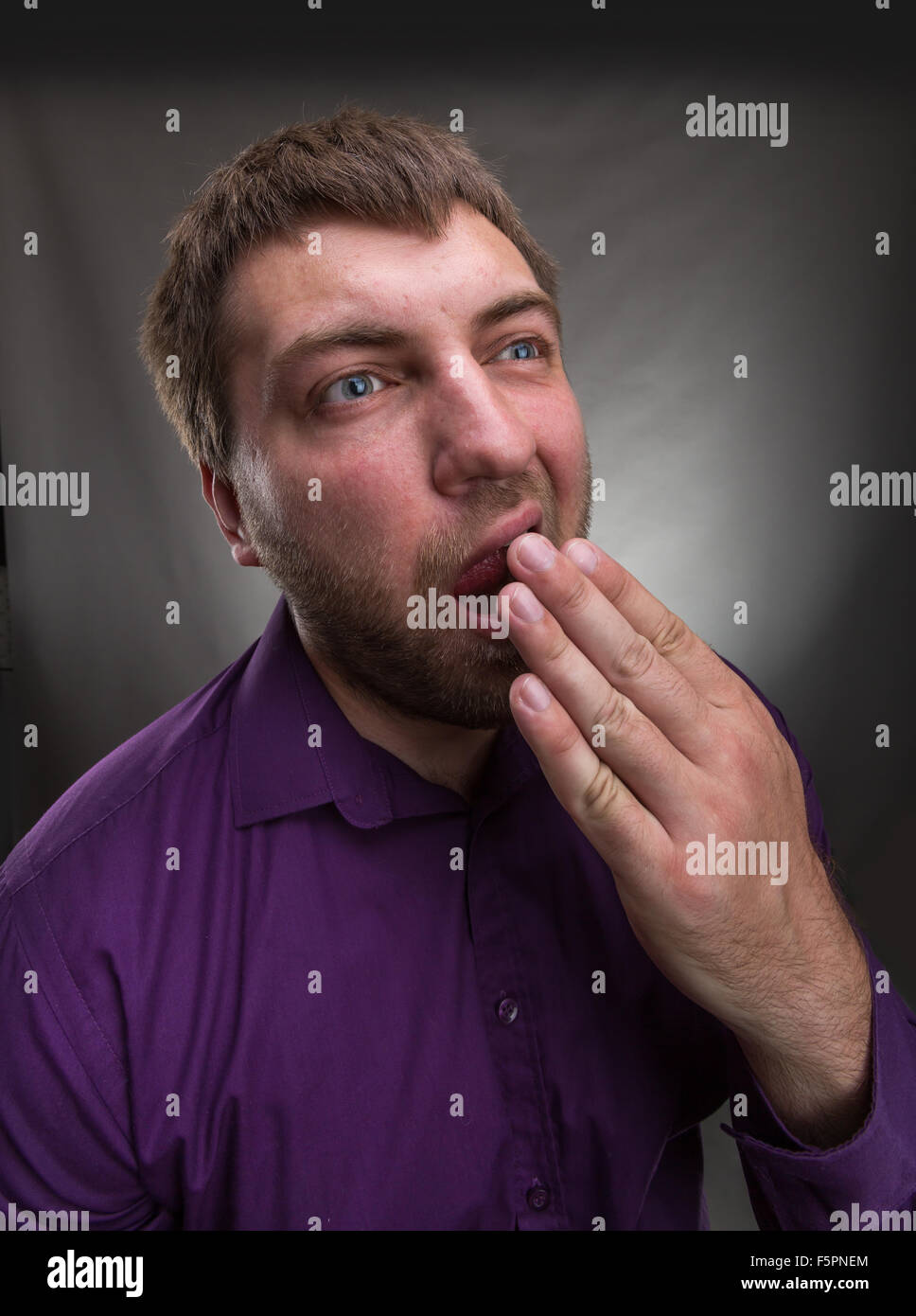Adult man yawning over grey background Stock Photo - Alamy