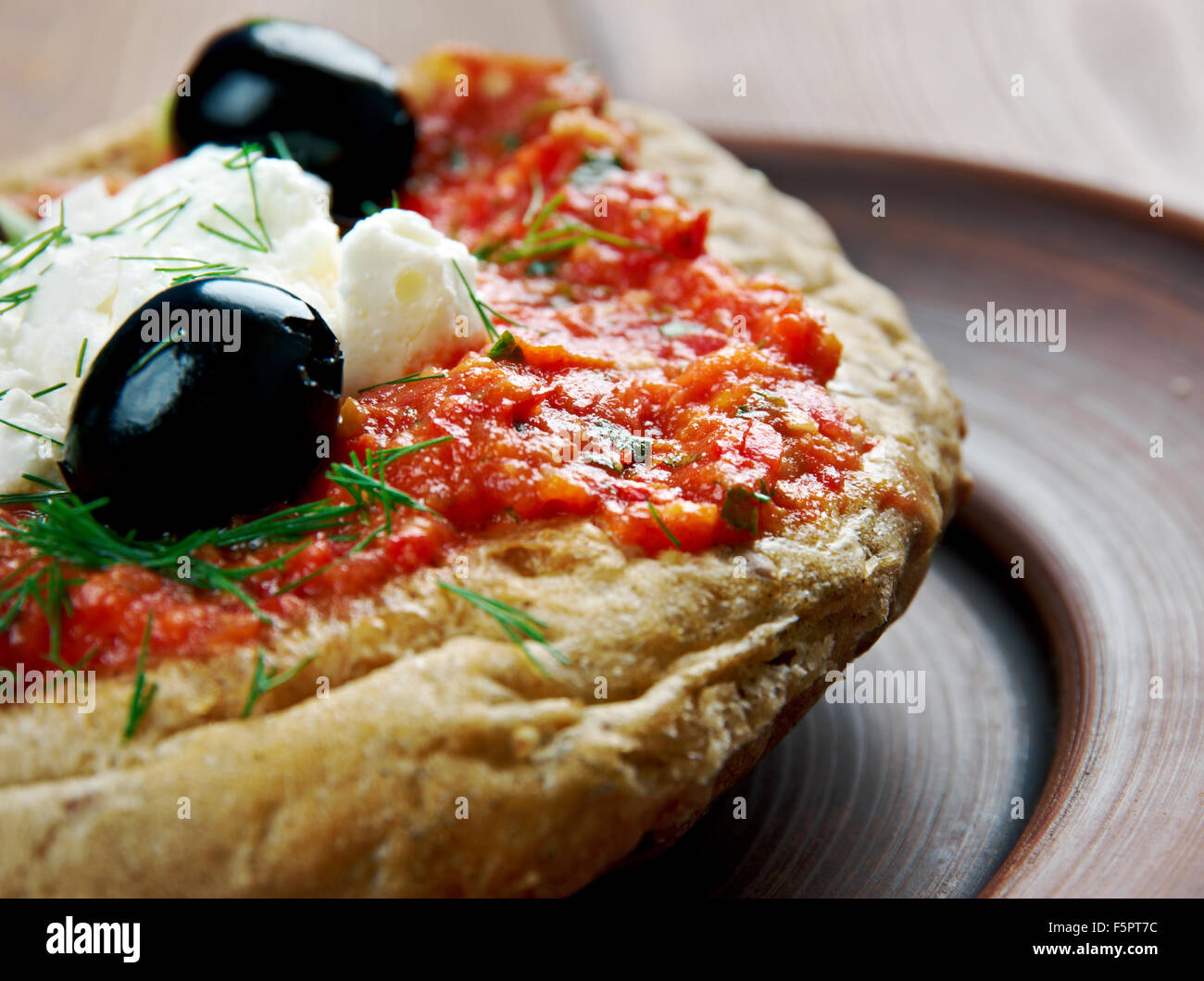 Dakos - slice bread topped with chopped tomatoes and crumbled feta ...