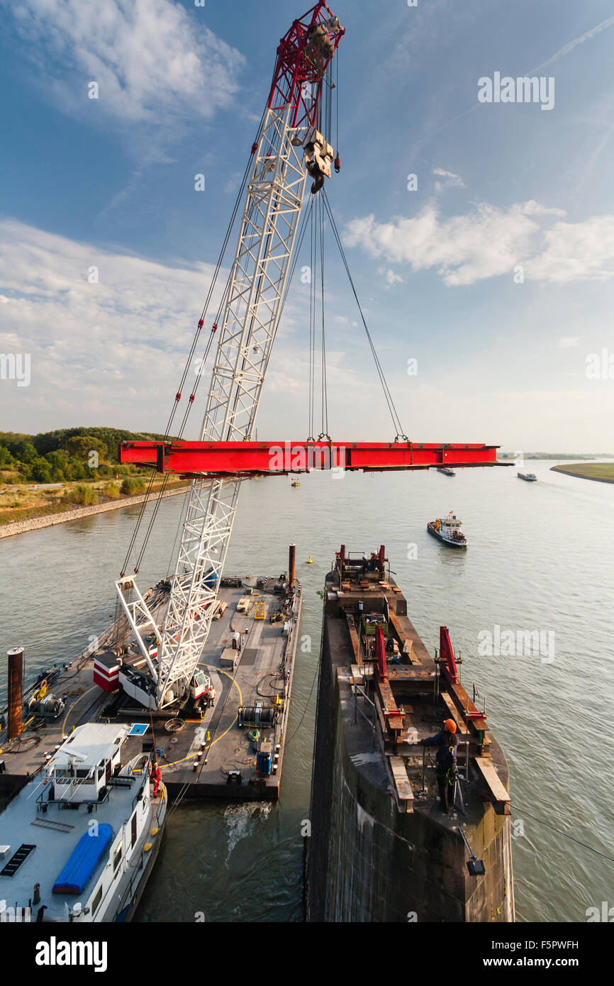 Floating crane carrying girder platform to support a bridge ...