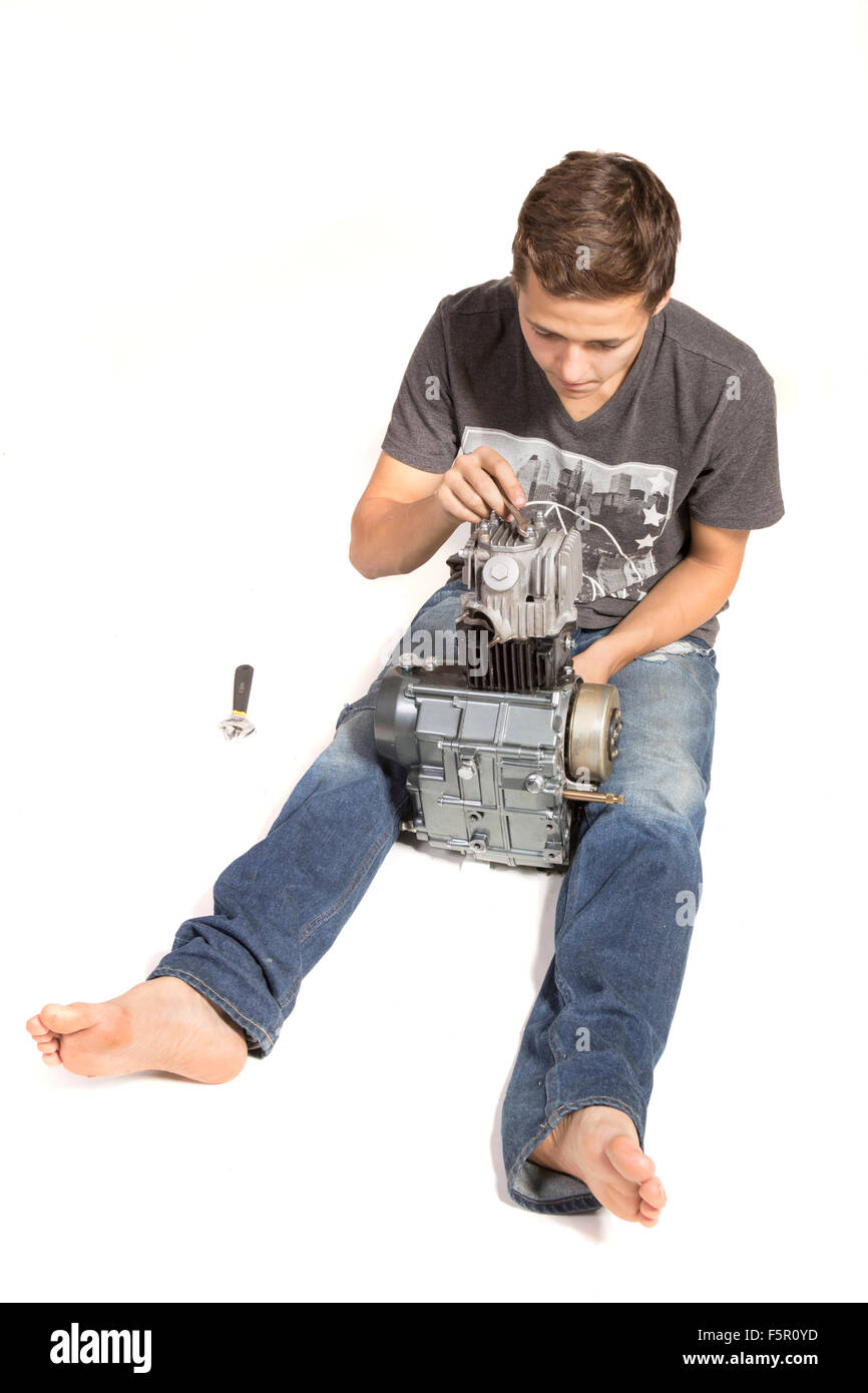 Teenage boy fixing engine Cut Out Stock Images & Pictures - Alamy