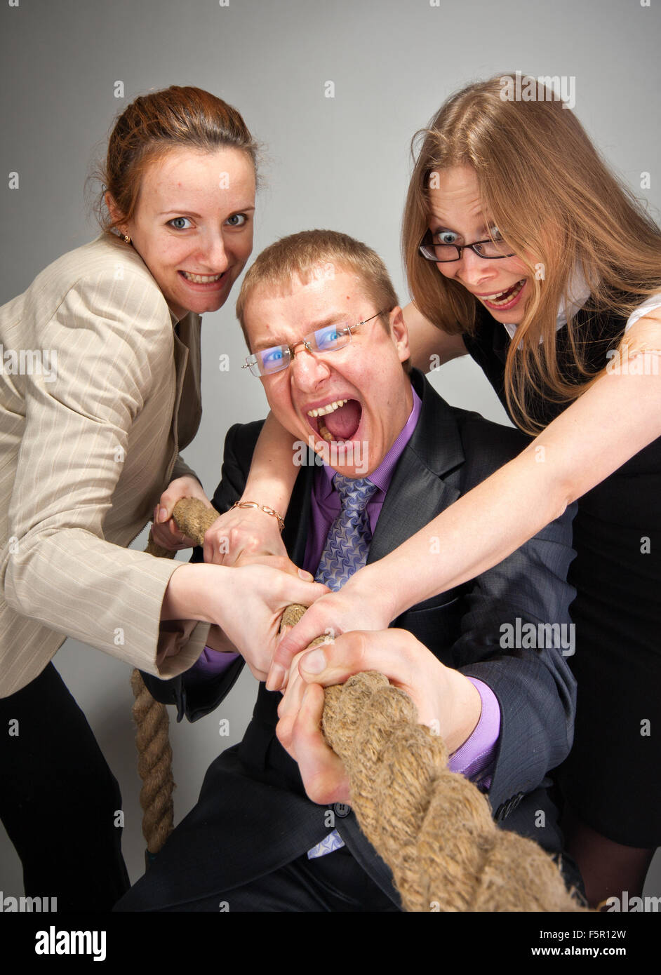 Portrait of business team pulling a rope Stock Photo - Alamy