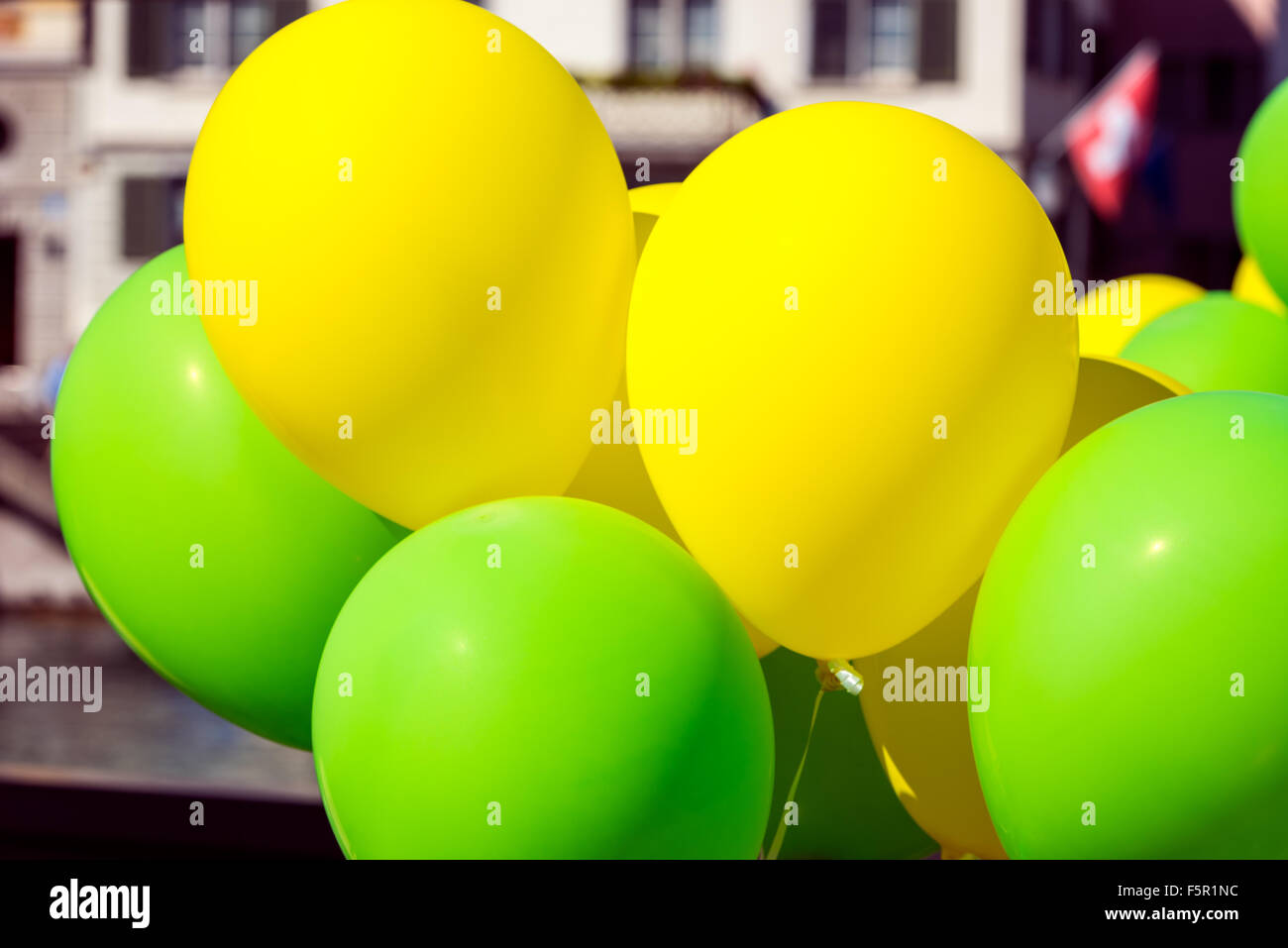 Bright yellow and green balloons on a city street event in summer Stock ...