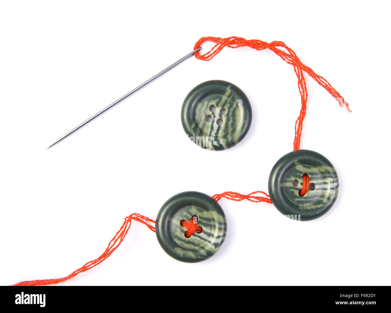 Sewing needle with red thread and buttons Stock Photo - Alamy