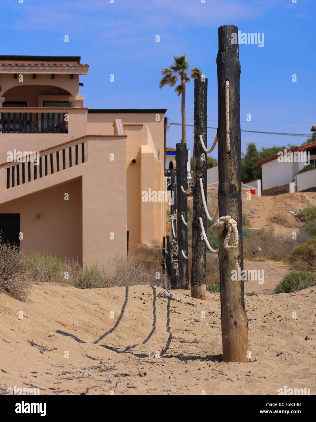 Rope and posts in beach dunes, with beach houses in background Stock ...