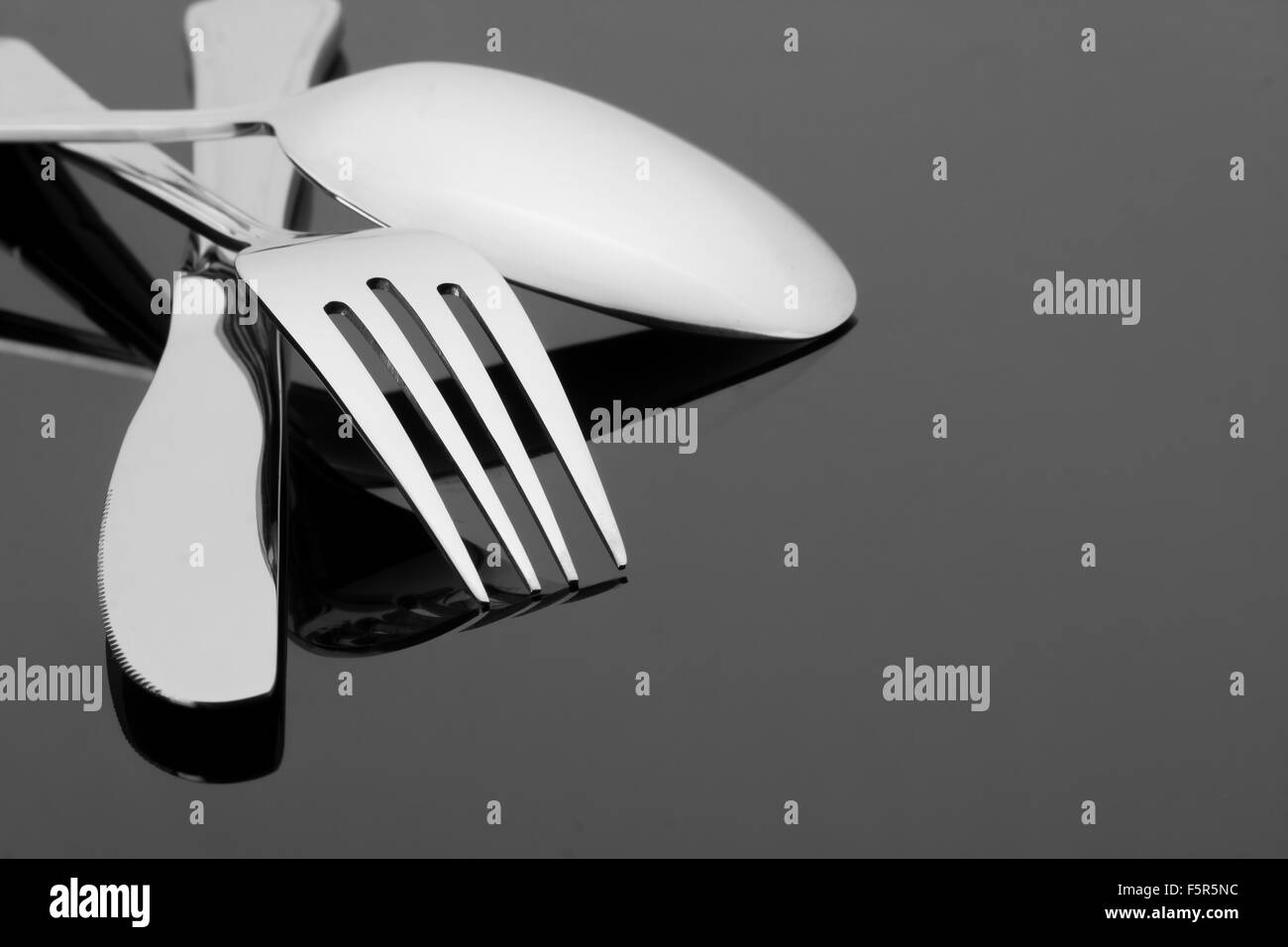 Side view of silver fork, knife and spoon on gray background Stock ...