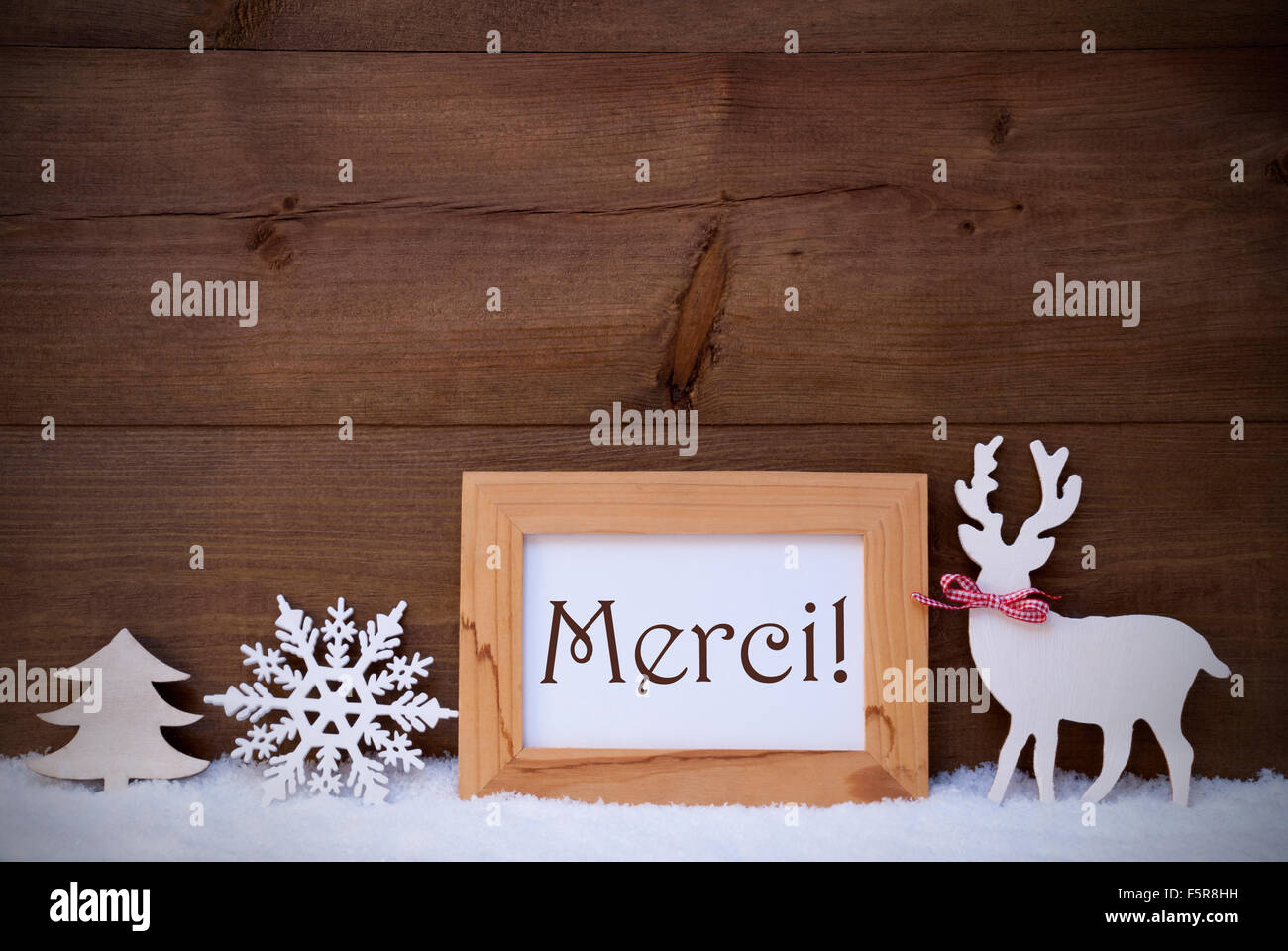 White Decoration On Snow, Text Merci Means Thank You Stock Photo - Alamy