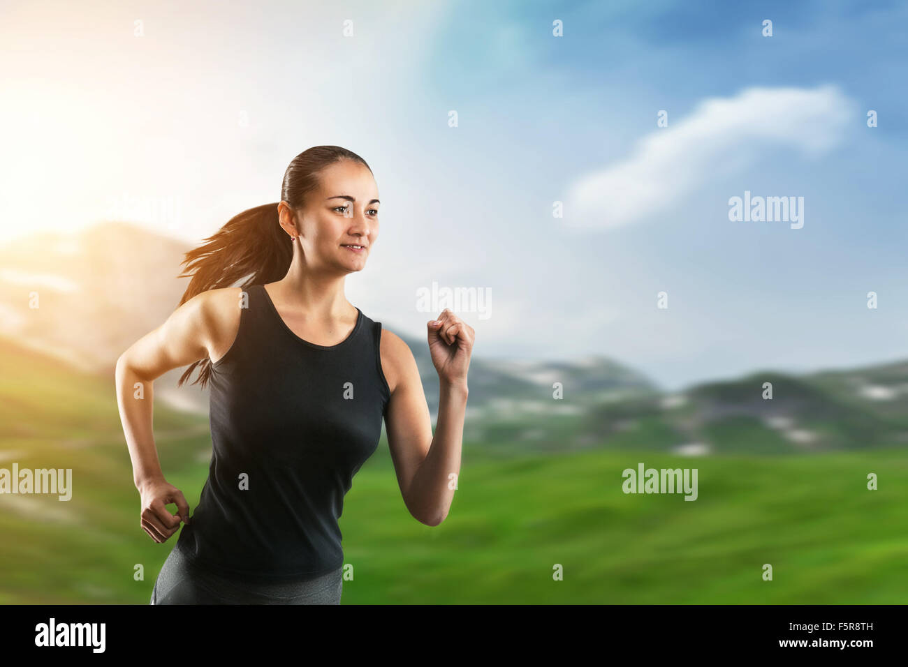 Sport woman running on green grass on blue sky background Stock Photo ...