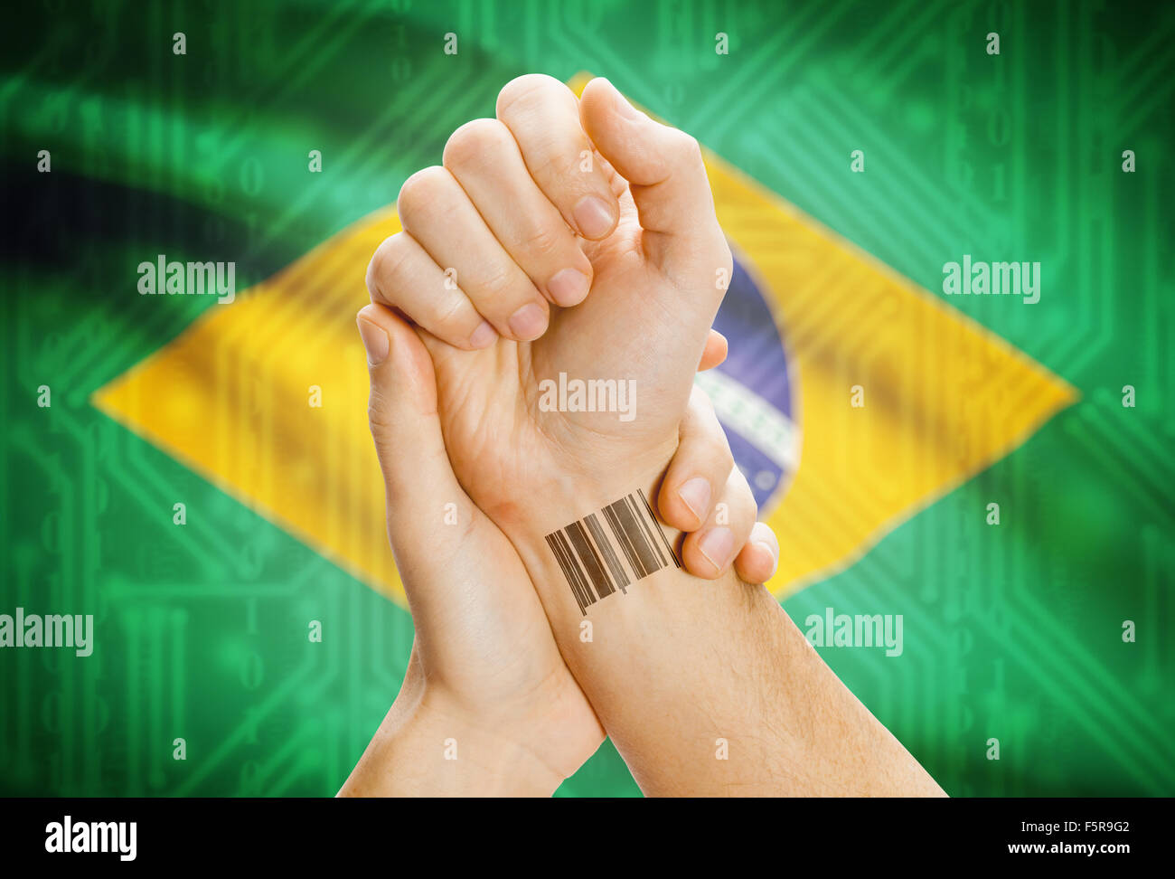 Barcode ID number on wrist of a human and national flag on background ...