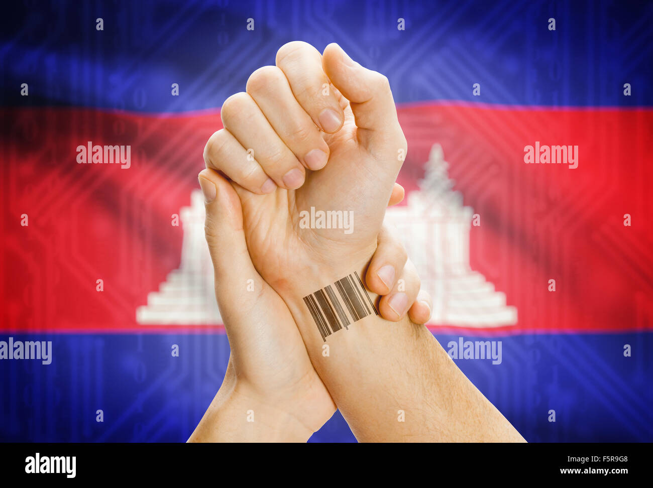 Barcode ID number on wrist of a human and national flag on background ...