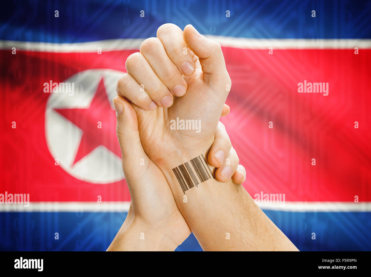 Barcode ID number on wrist of a human and national flag on background ...