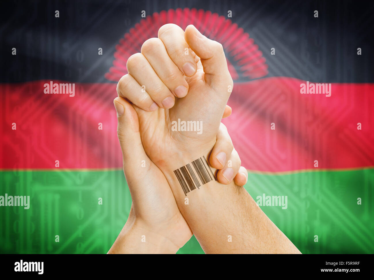 Barcode ID number on wrist of a human and national flag on background ...