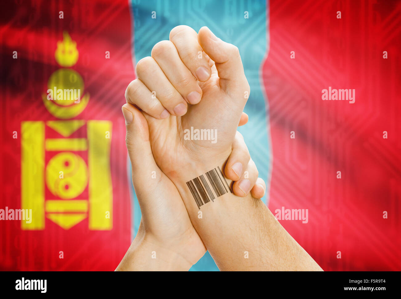 Barcode ID number on wrist of a human and national flag on background ...