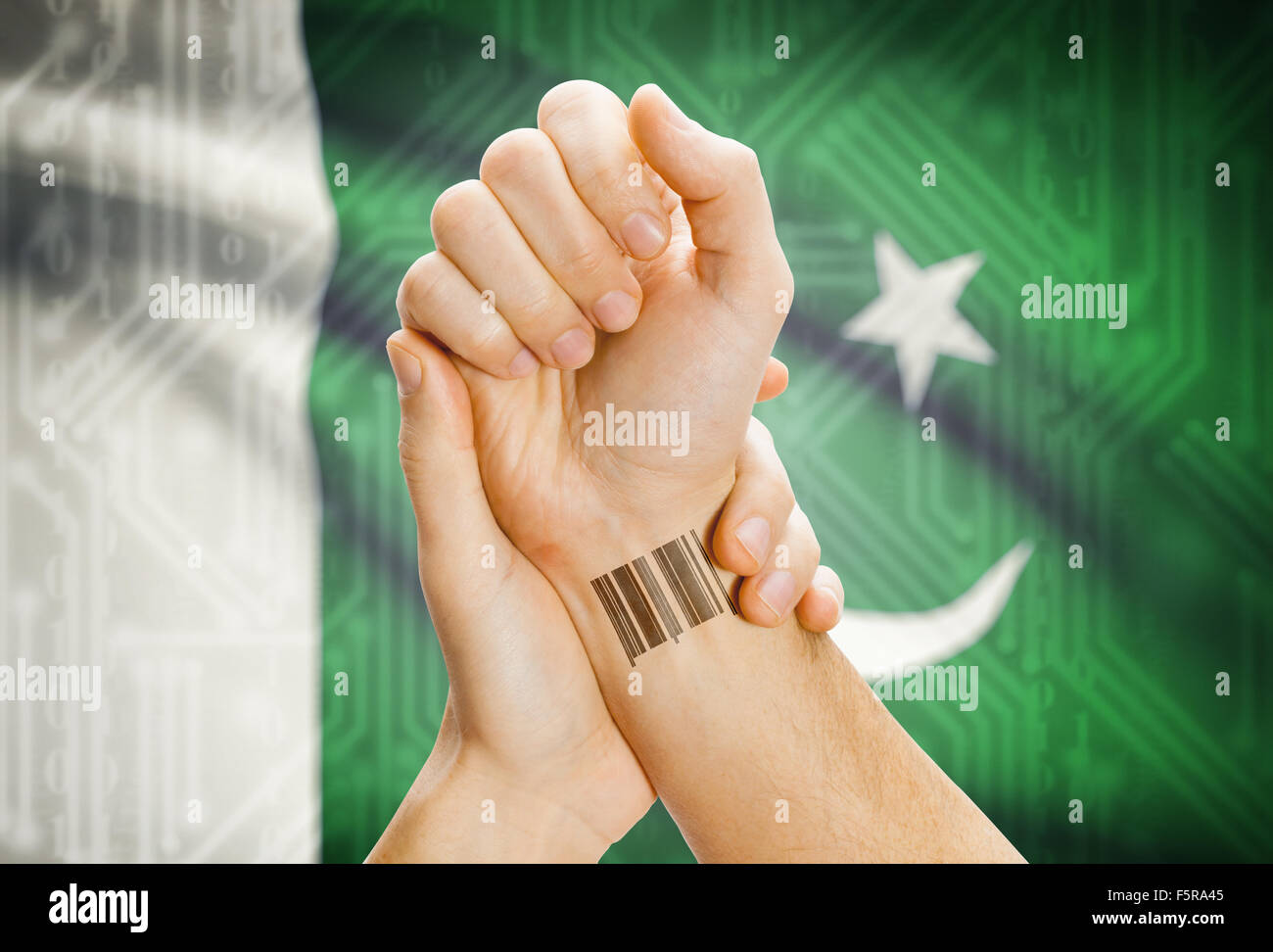 Barcode ID number on wrist of a human and national flag on background ...