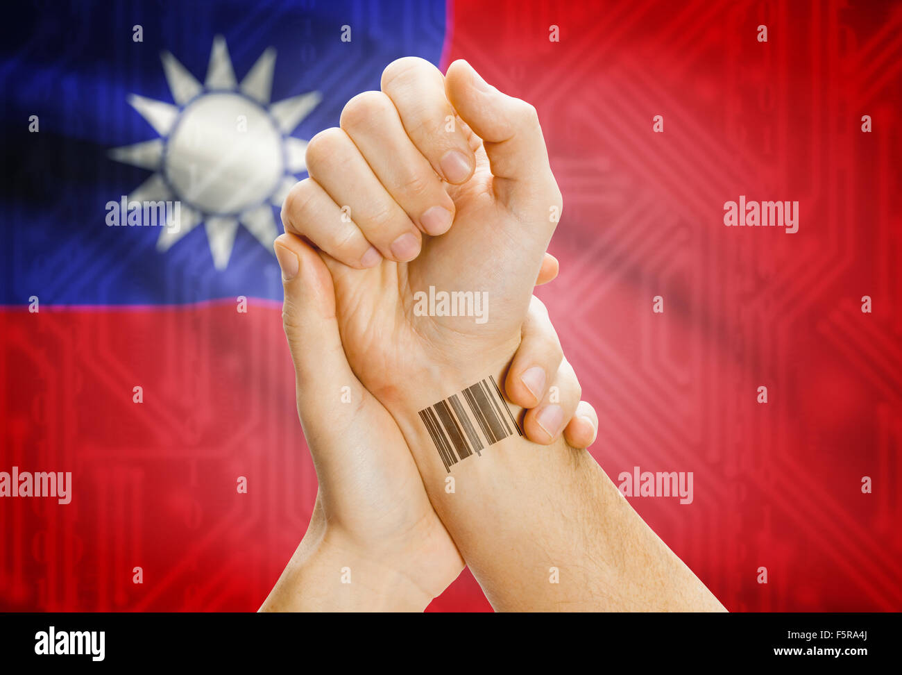 Barcode ID number on wrist of a human and national flag on background ...