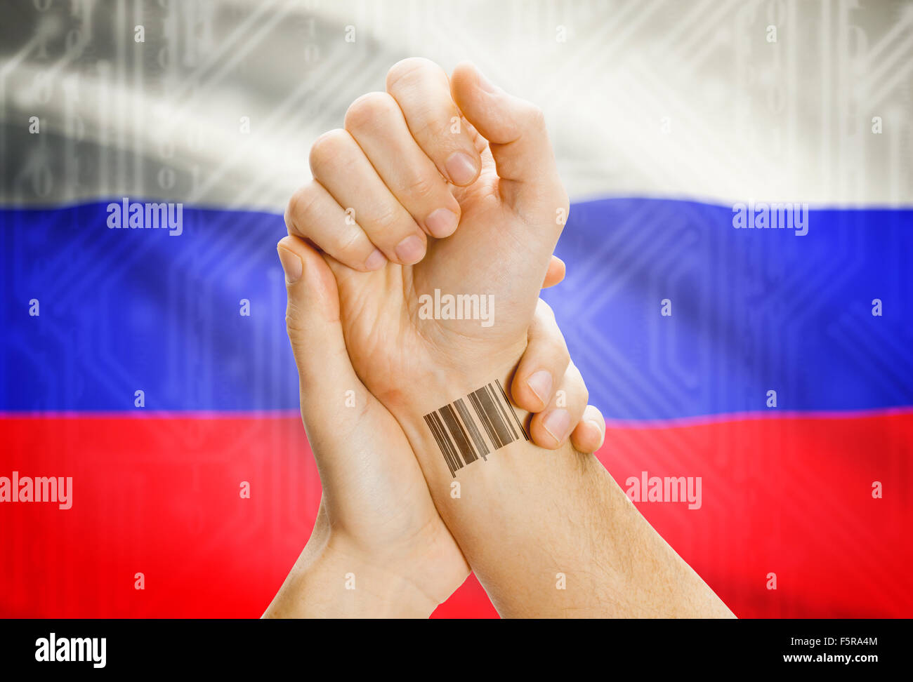 Barcode ID number on wrist of a human and national flag on background ...