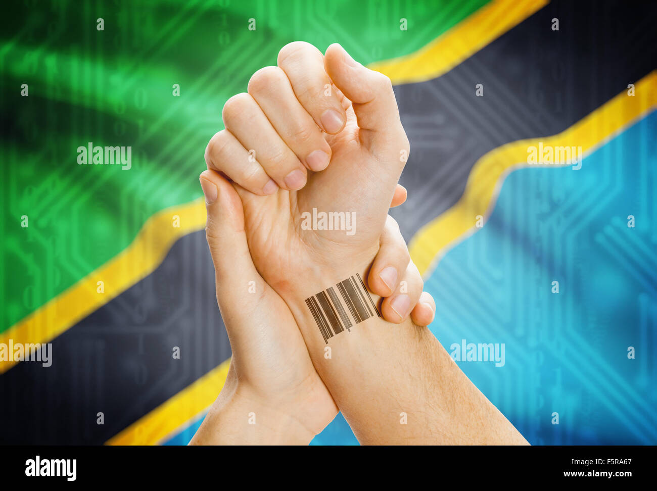 Barcode ID number on wrist of a human and national flag on background ...
