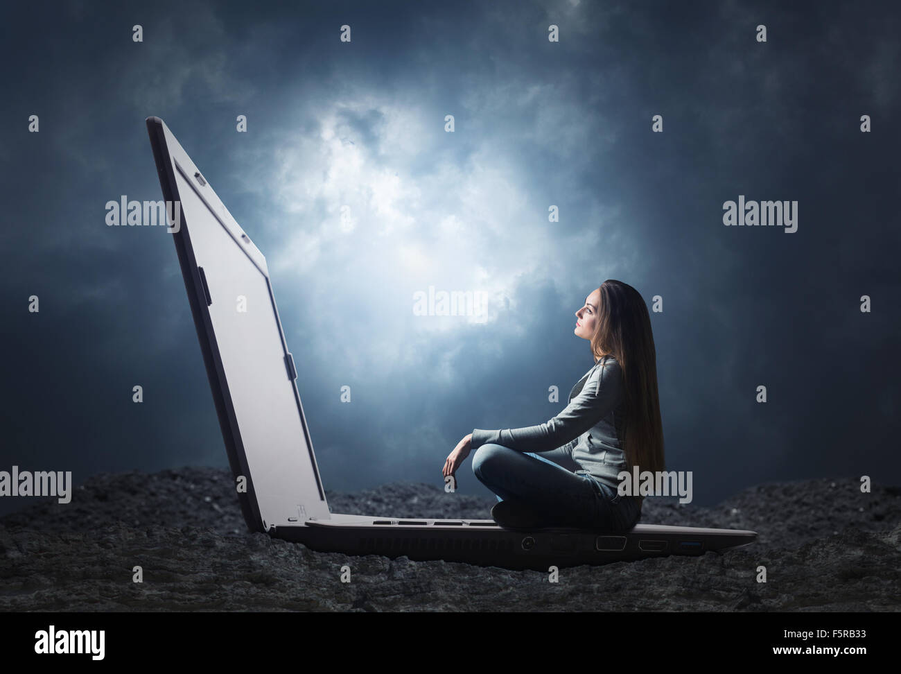 Woman is sitting and looking at screen on a big laptop Stock Photo - Alamy