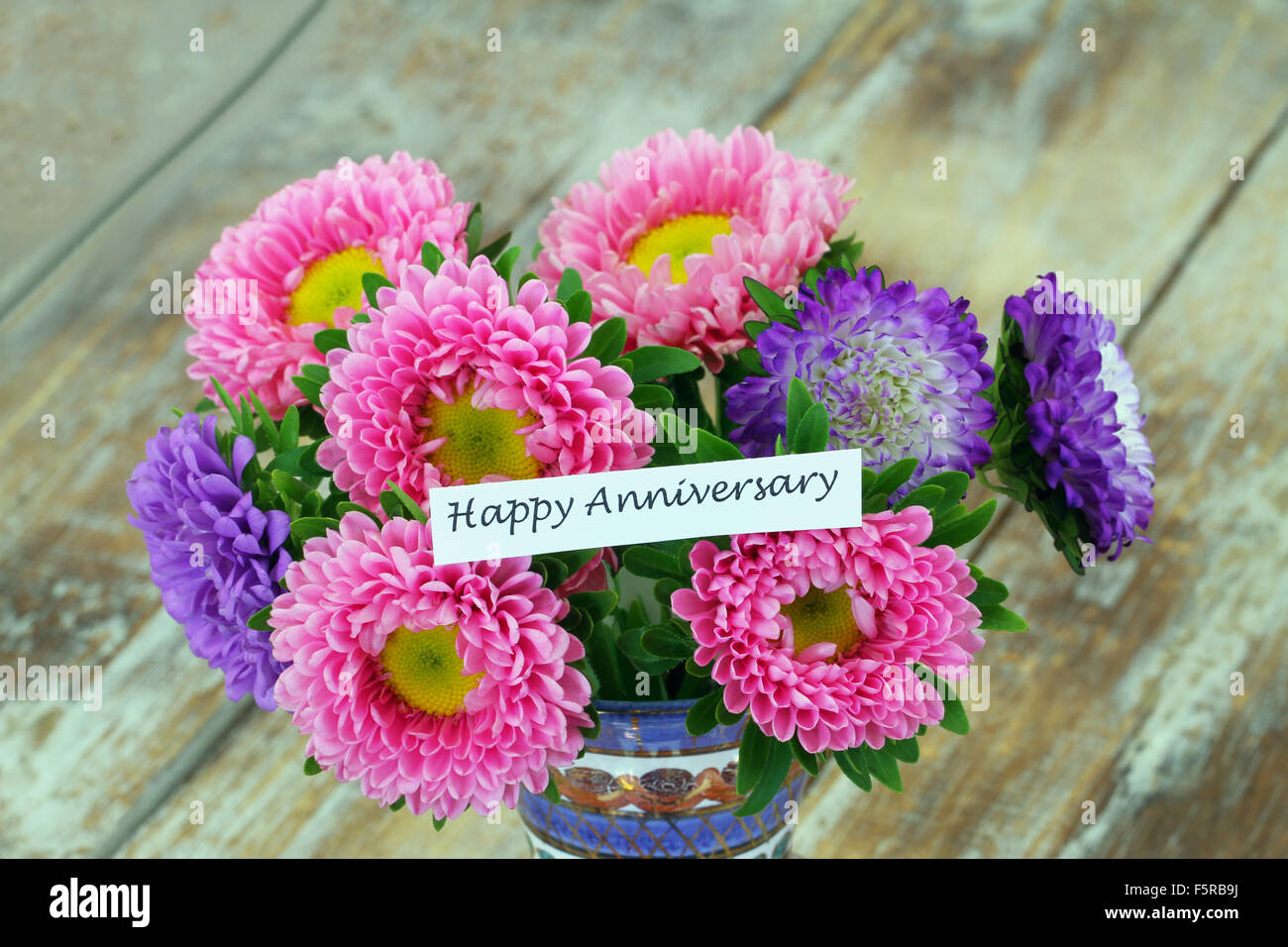 Happy Anniversary card with colorful aster flowers bouquet on rustic ...
