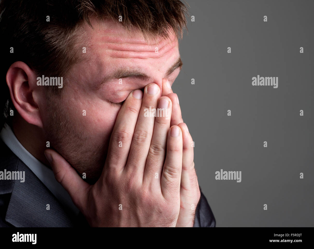 Exhausted sad businessman covering his face by hands Stock Photo - Alamy