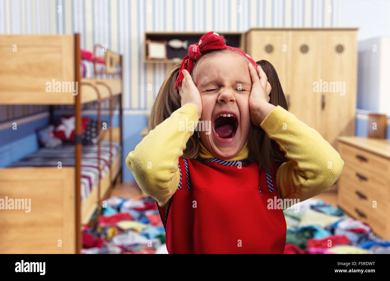 Little girl screaming at home with her ears covered by hands Stock ...