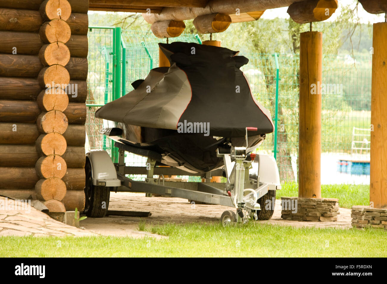 Covered jet ski in garage Stock Photo - Alamy
