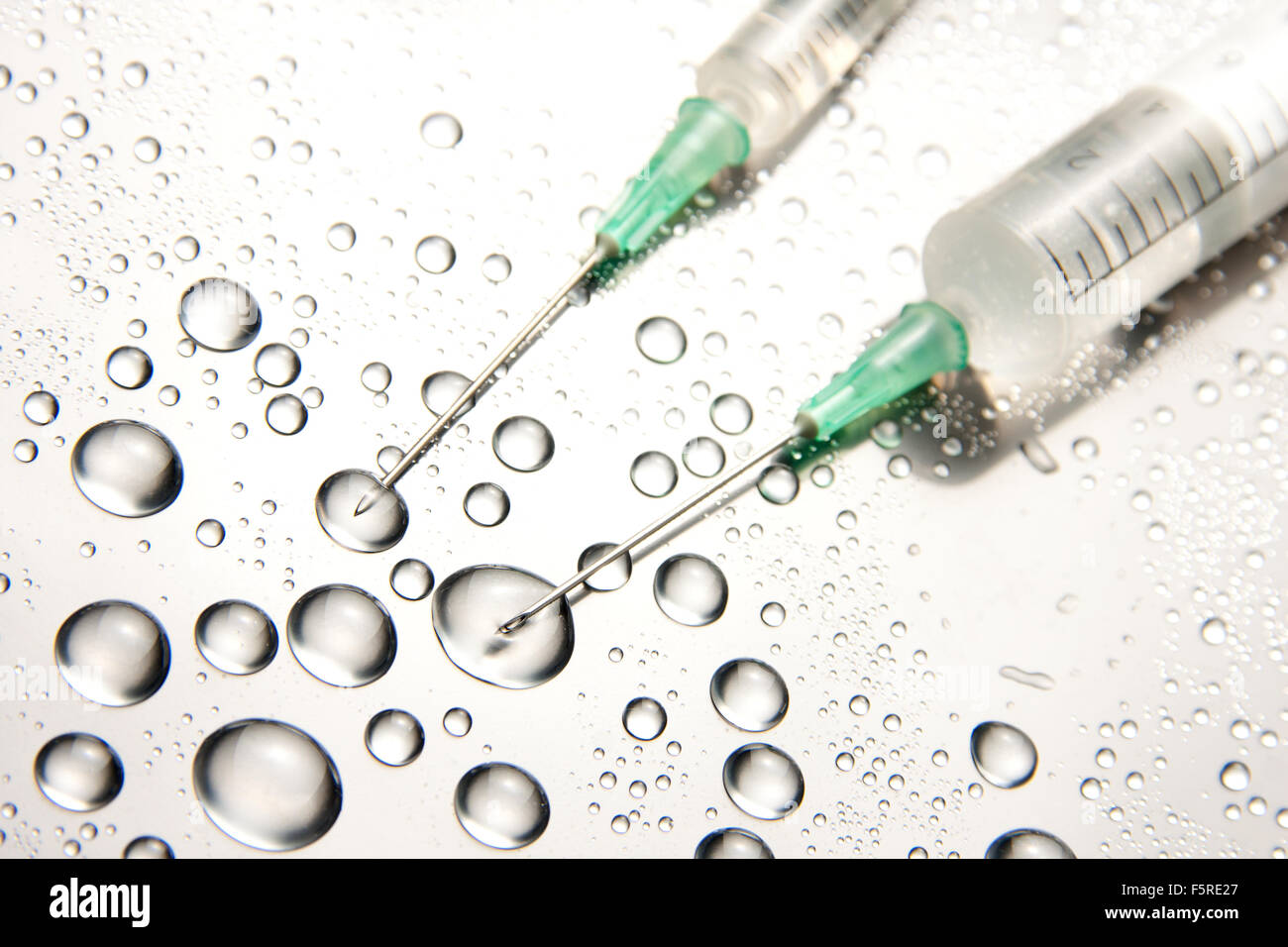 Two medical syringes and water drops Stock Photo - Alamy
