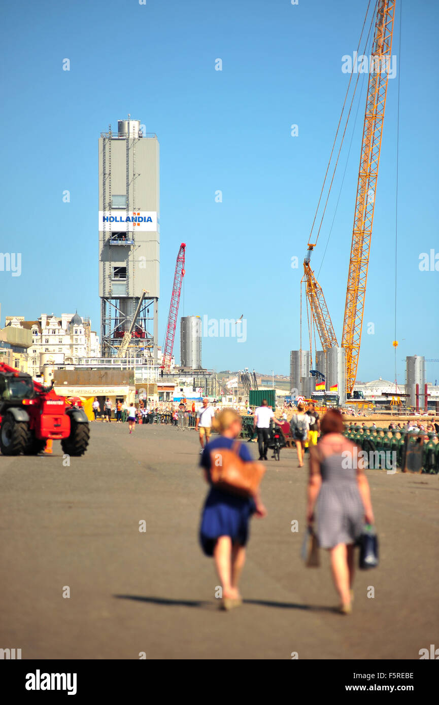 Pedestrians walk along the Brighton seafront with the i360 observation ...