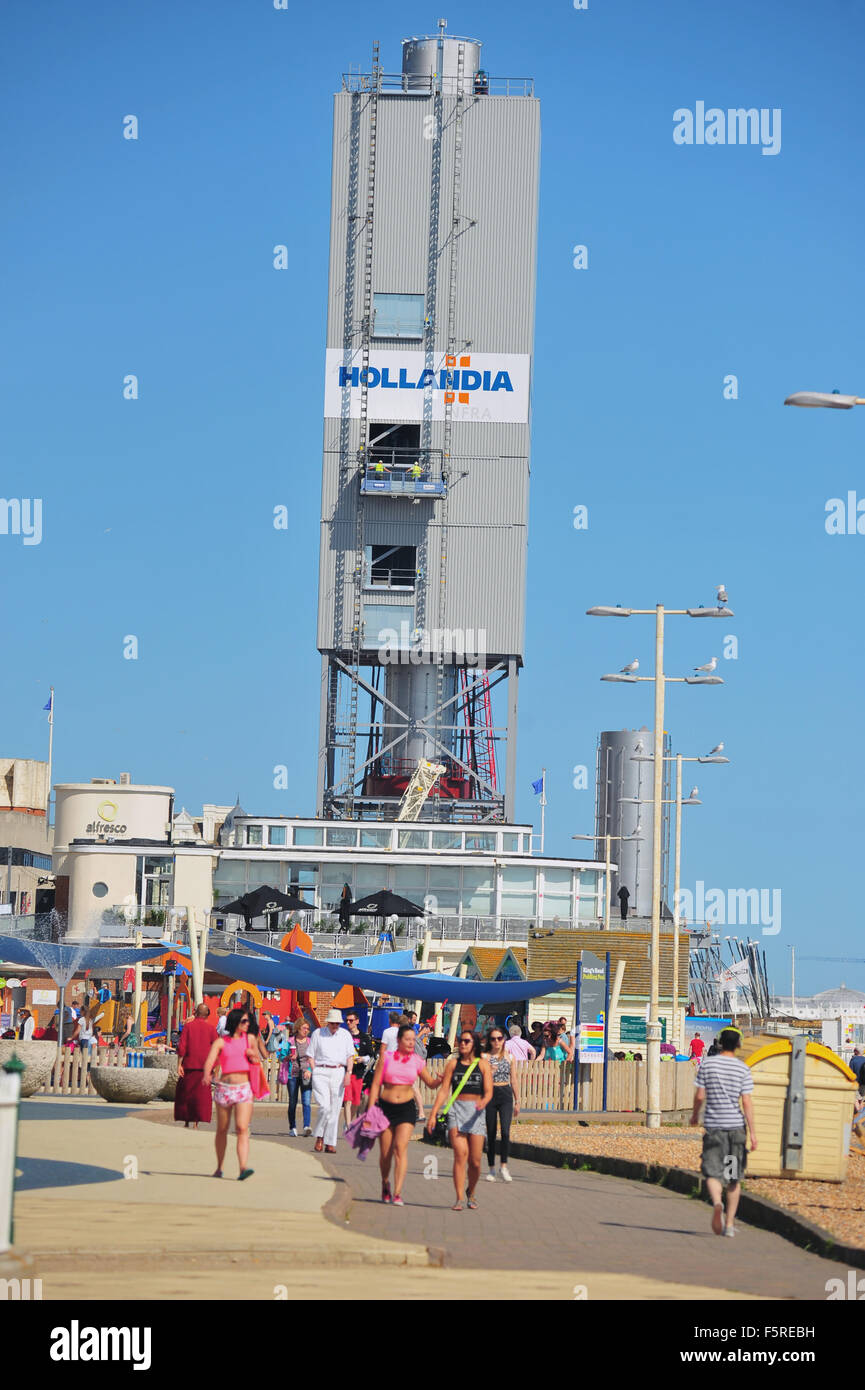 Pedestrians walk along the Brighton seafront with the i360 observation ...