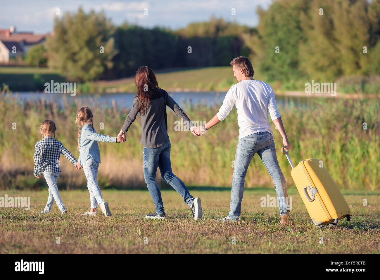 Happy family with suitcase walking outdoors Stock Photo - Alamy