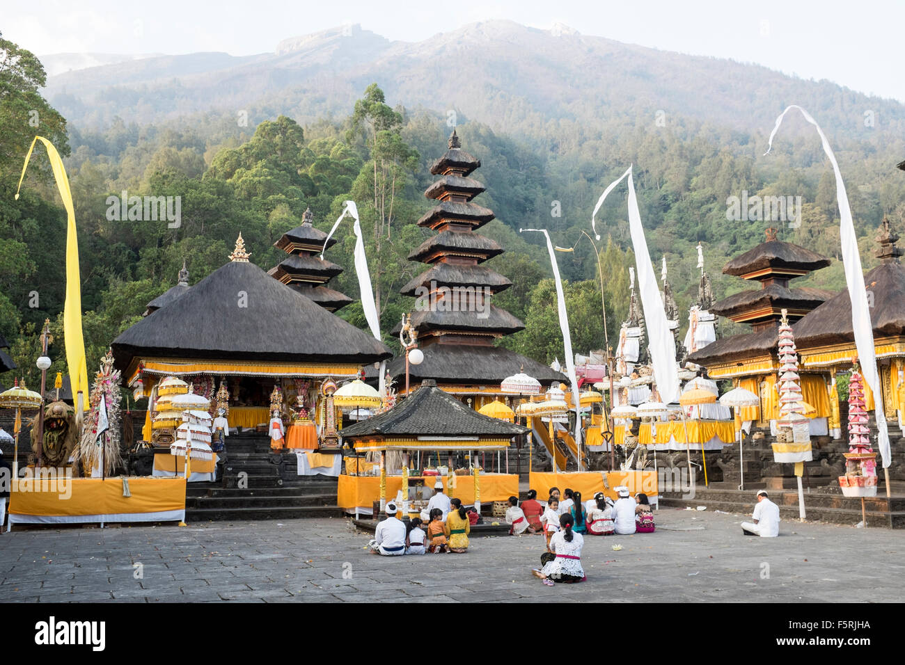 Worshippers at the Pasar Agung Temple with the summit of the volcano in ...