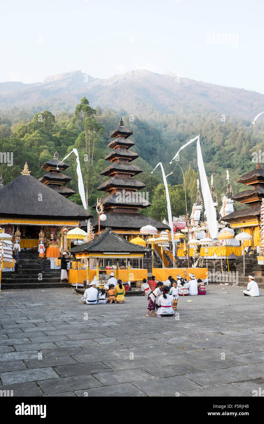 Worshippers at the Pasar Agung Temple with the summit of the volcano in ...