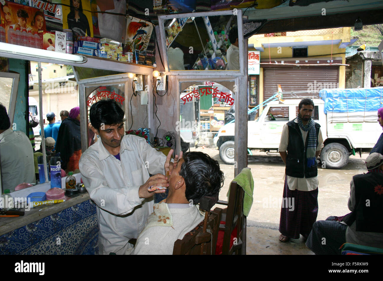 Delhi,India - April 30,2004: A barber giving a clean shave to the ...