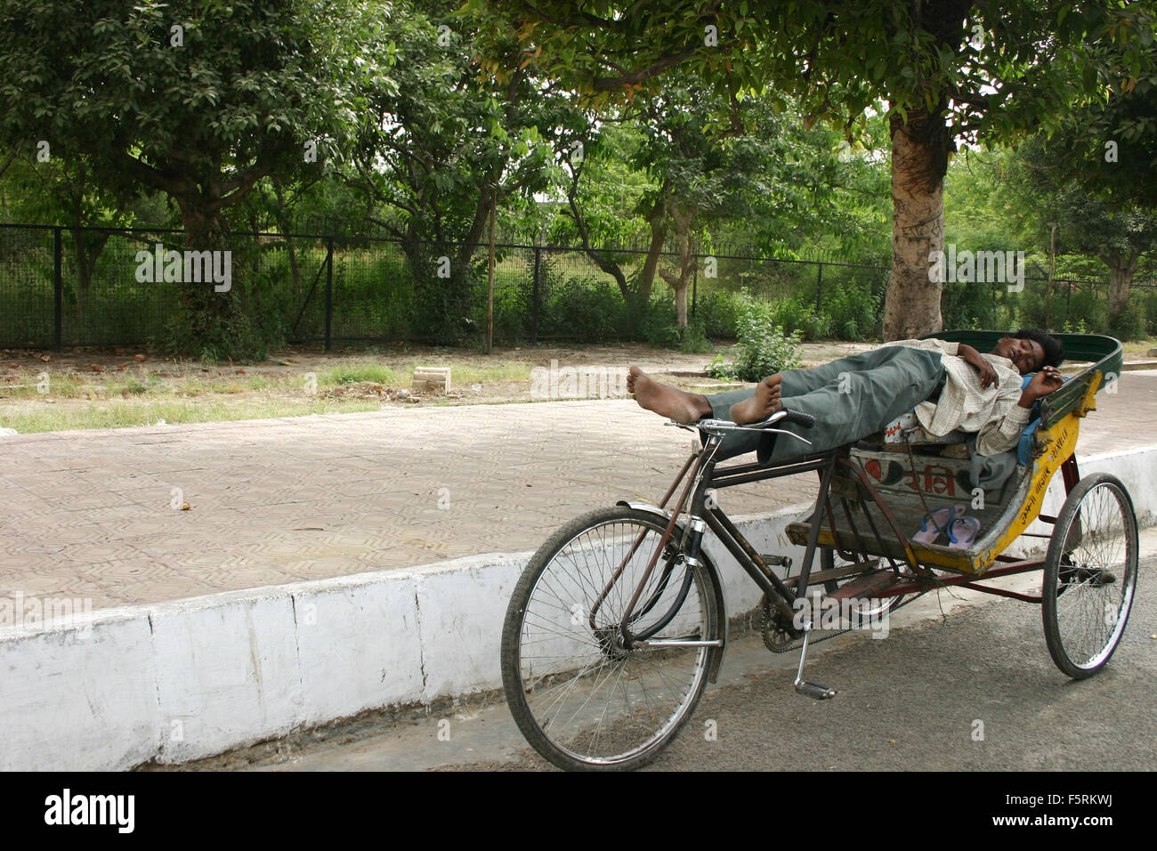 Delhi,India April 17 2004 : A cycle rickshaw driver takes a nap after a ...