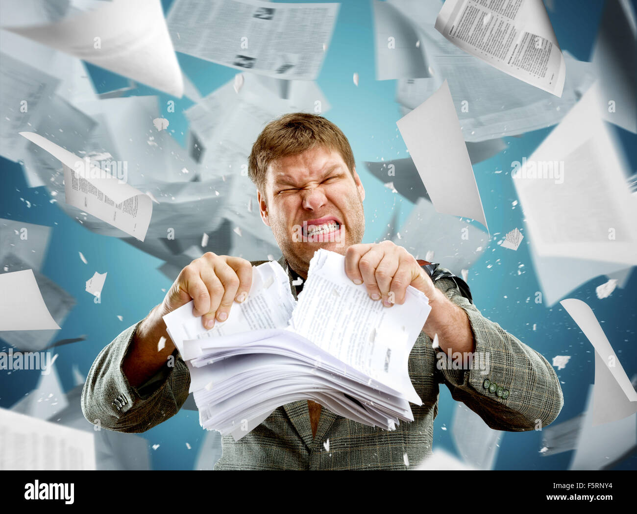 Stressed businessman tearing out stack of paper Stock Photo - Alamy