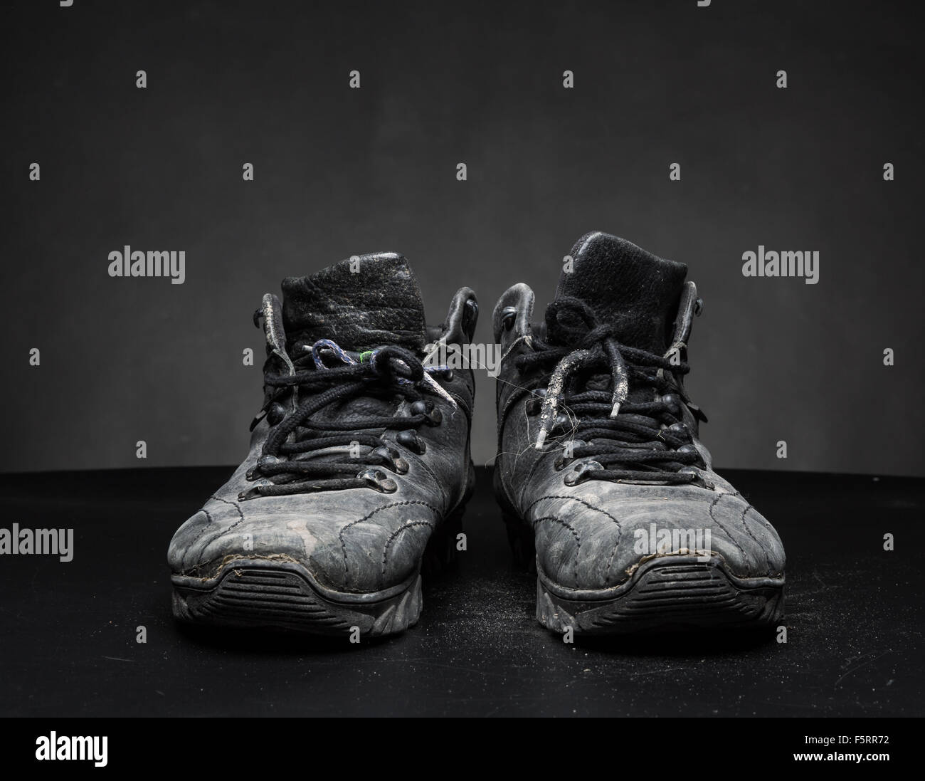 Old black worn out work shoes on the floor Stock Photo - Alamy