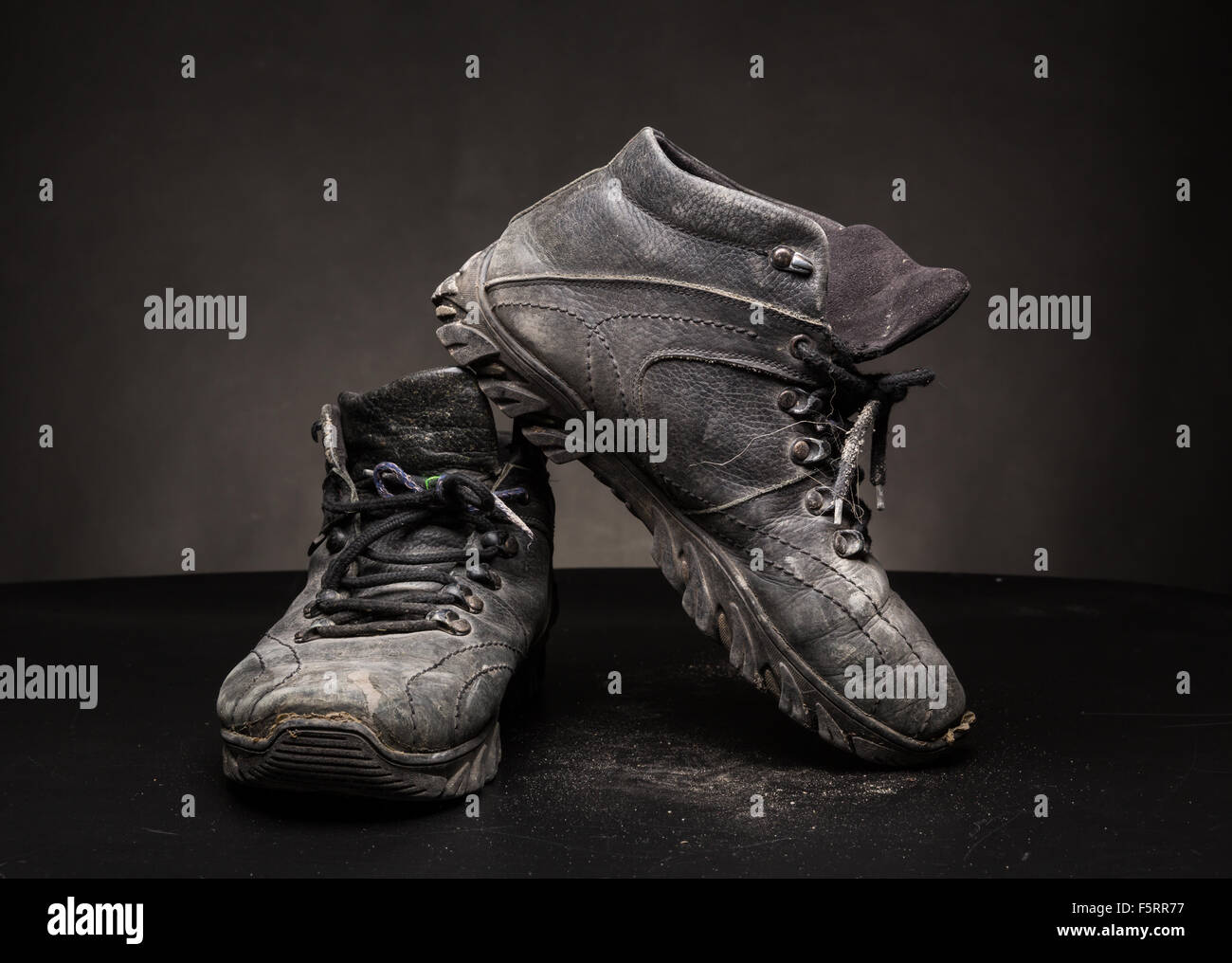 A pair of old black worn out shoes on the floor Stock Photo - Alamy