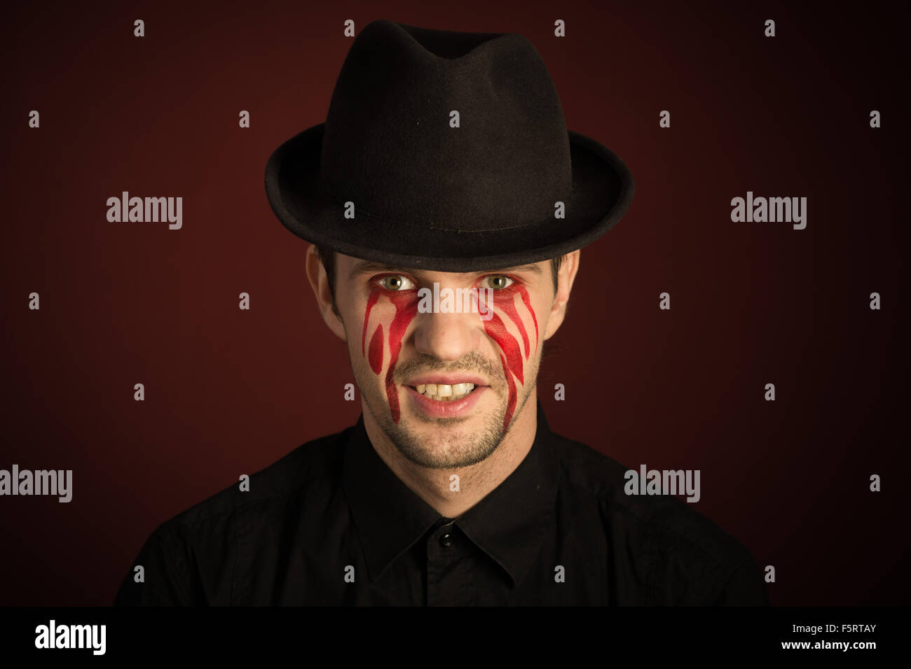portrait of man with bloody tears on burgundy background Stock Photo ...