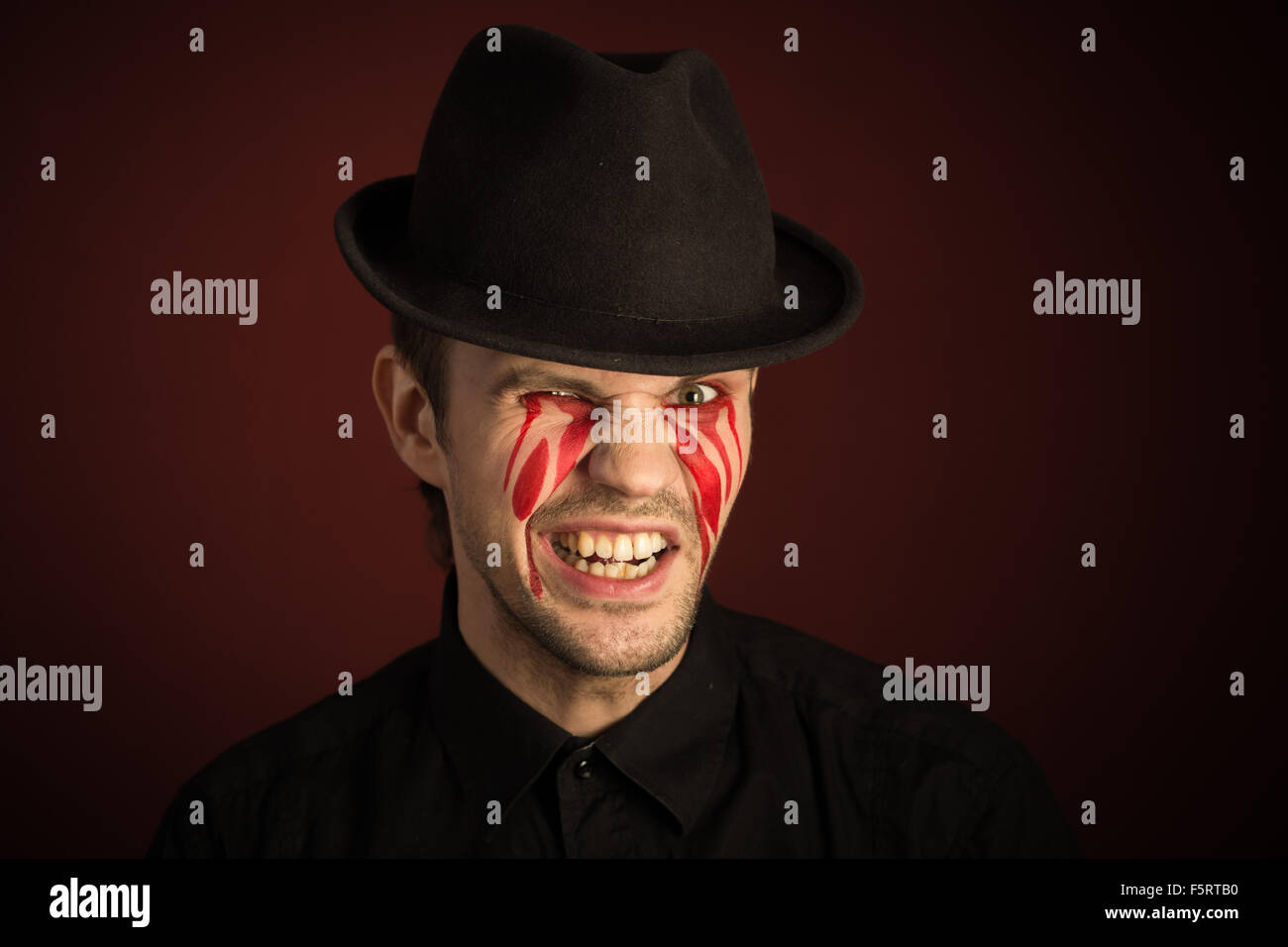 portrait of man with bloody tears on burgundy background Stock Photo ...