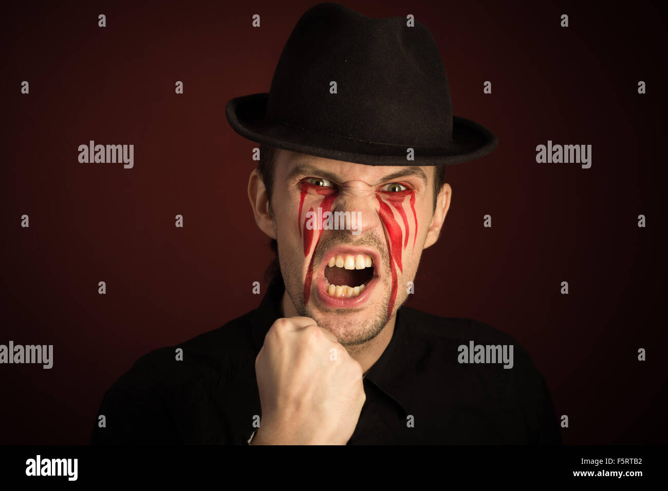 portrait of man with bloody tears on burgundy background Stock Photo ...