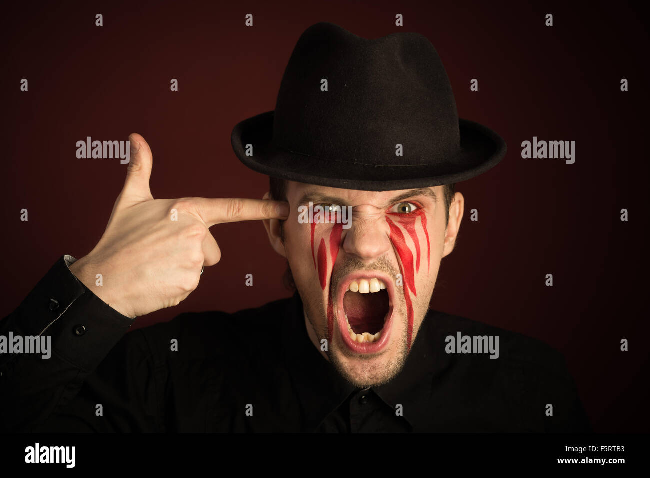 portrait of man with bloody tears on burgundy background Stock Photo ...