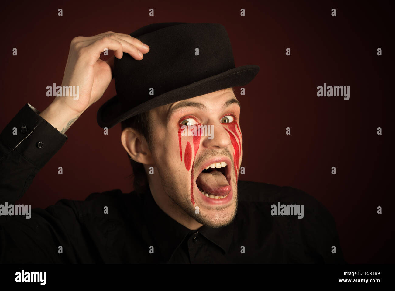 portrait of man with bloody tears on burgundy background Stock Photo ...