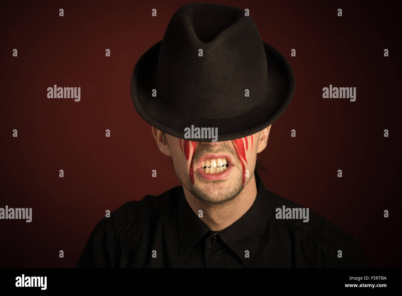 portrait of man with bloody tears on burgundy background Stock Photo ...