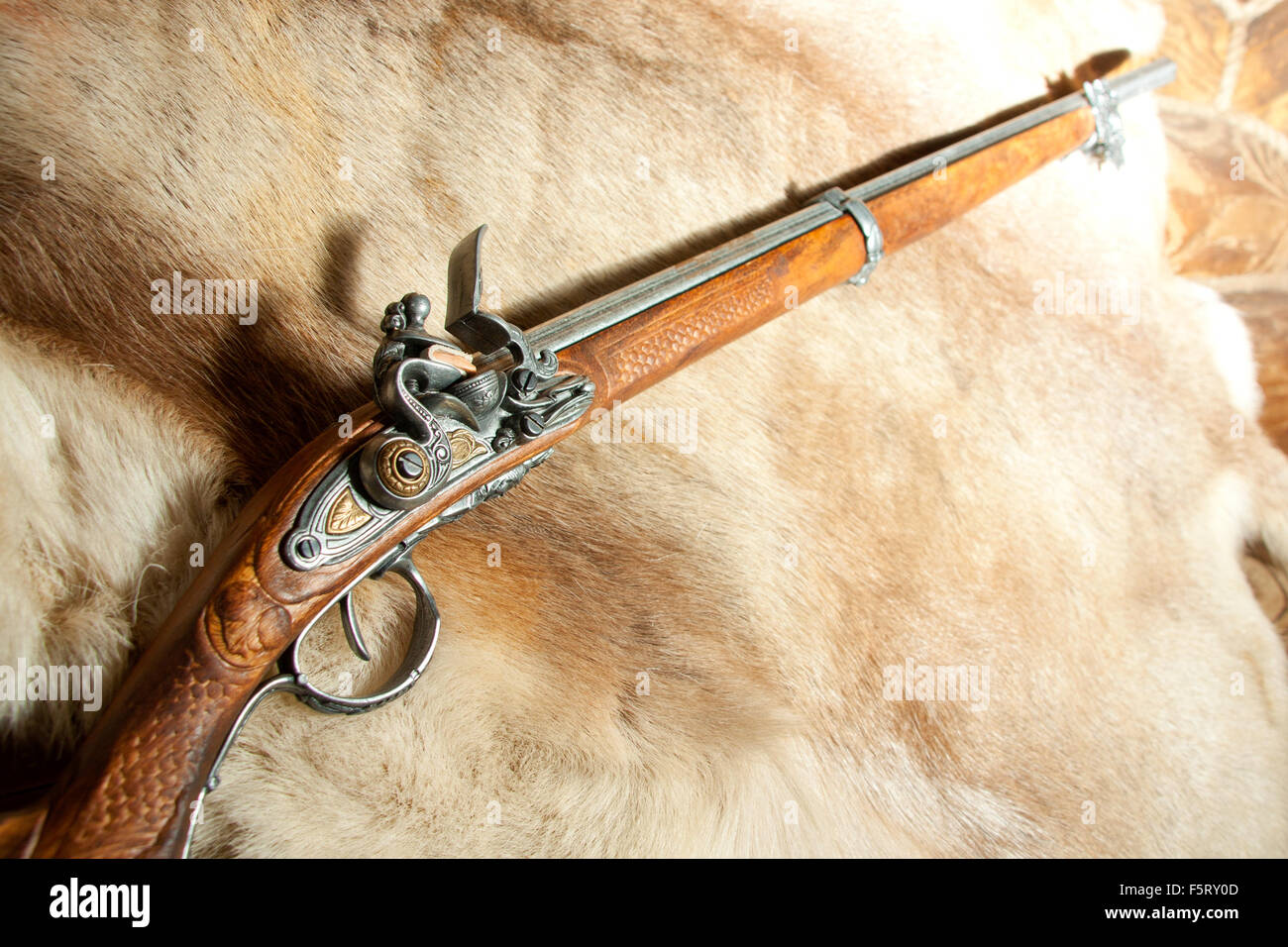 Retro wooden rifle on stuffed animal's skin Stock Photo - Alamy