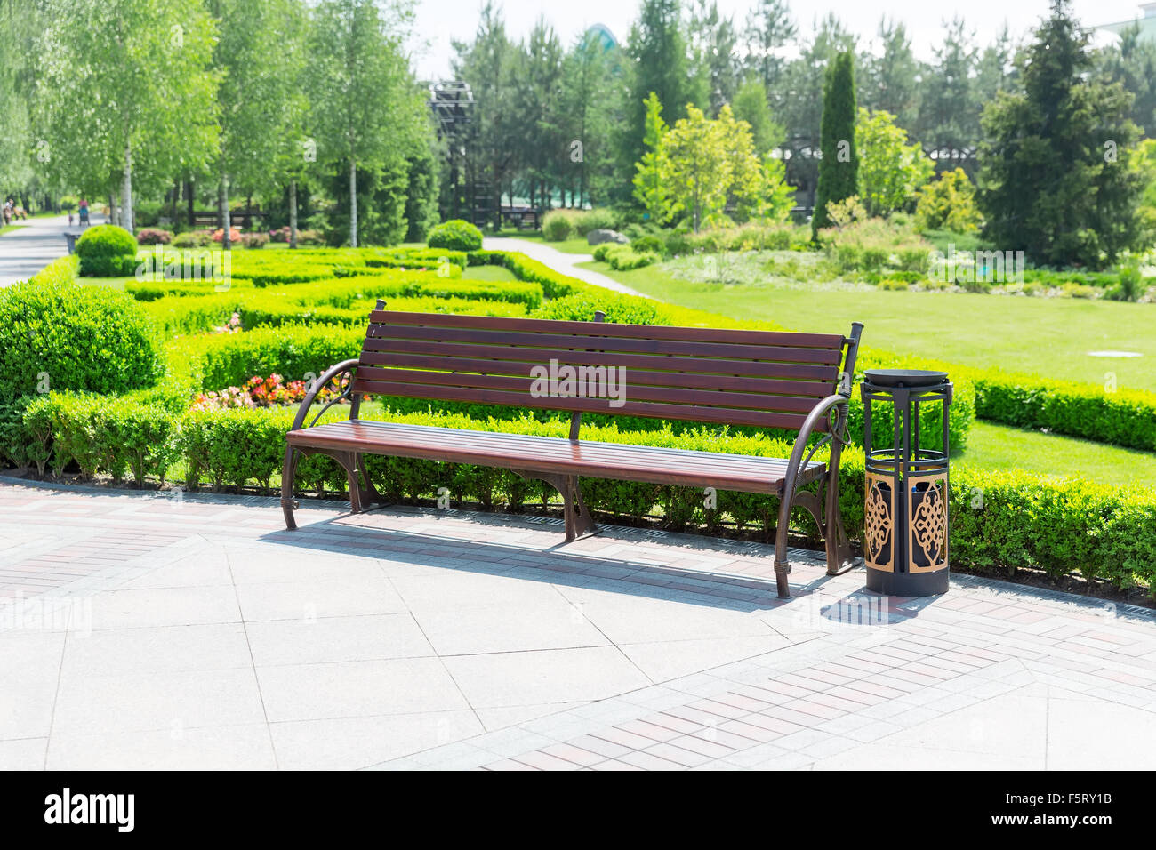 Bench in the park against meadow Stock Photo - Alamy